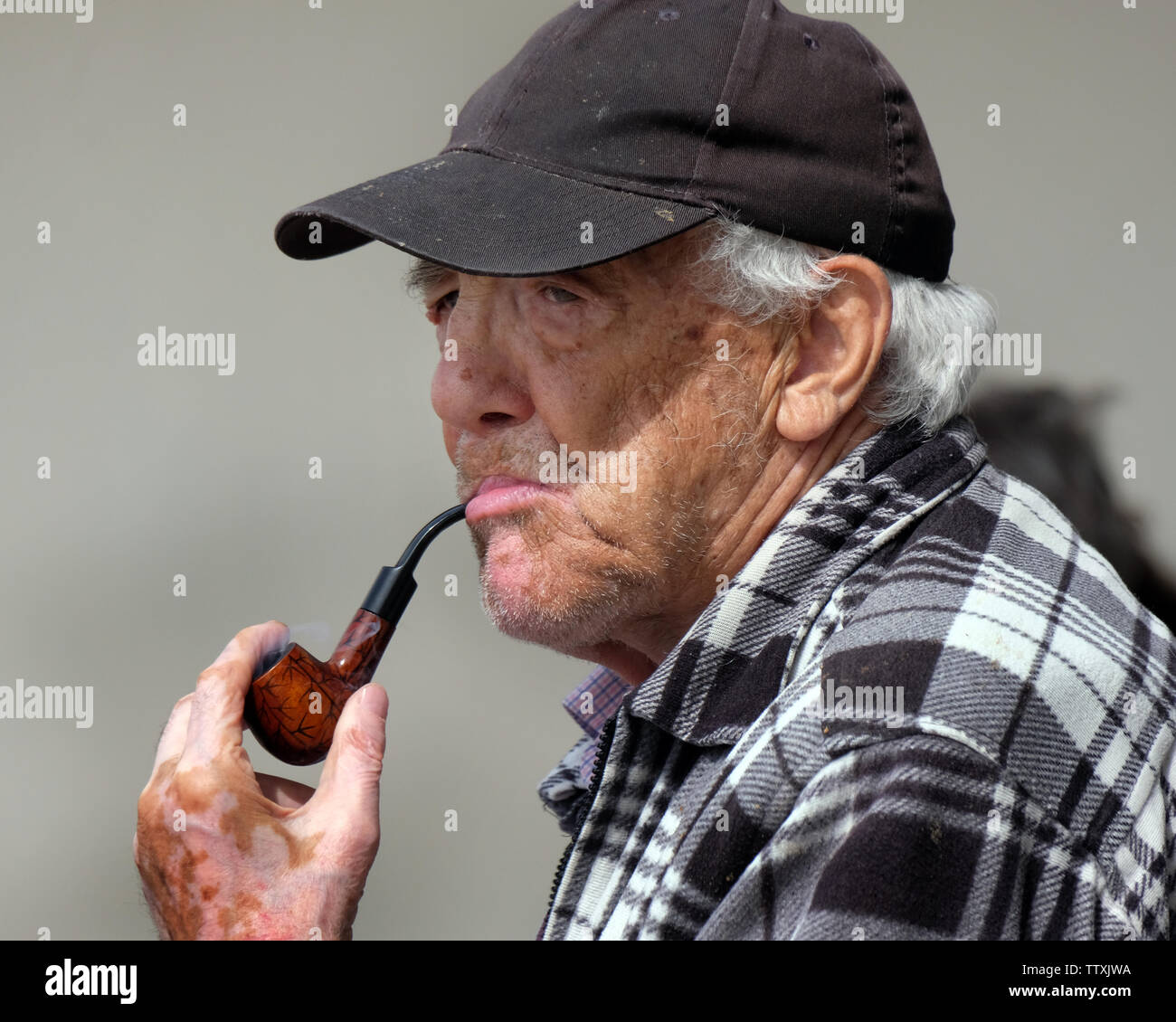 Old man in sun smoking pipe Stock Photo - Alamy