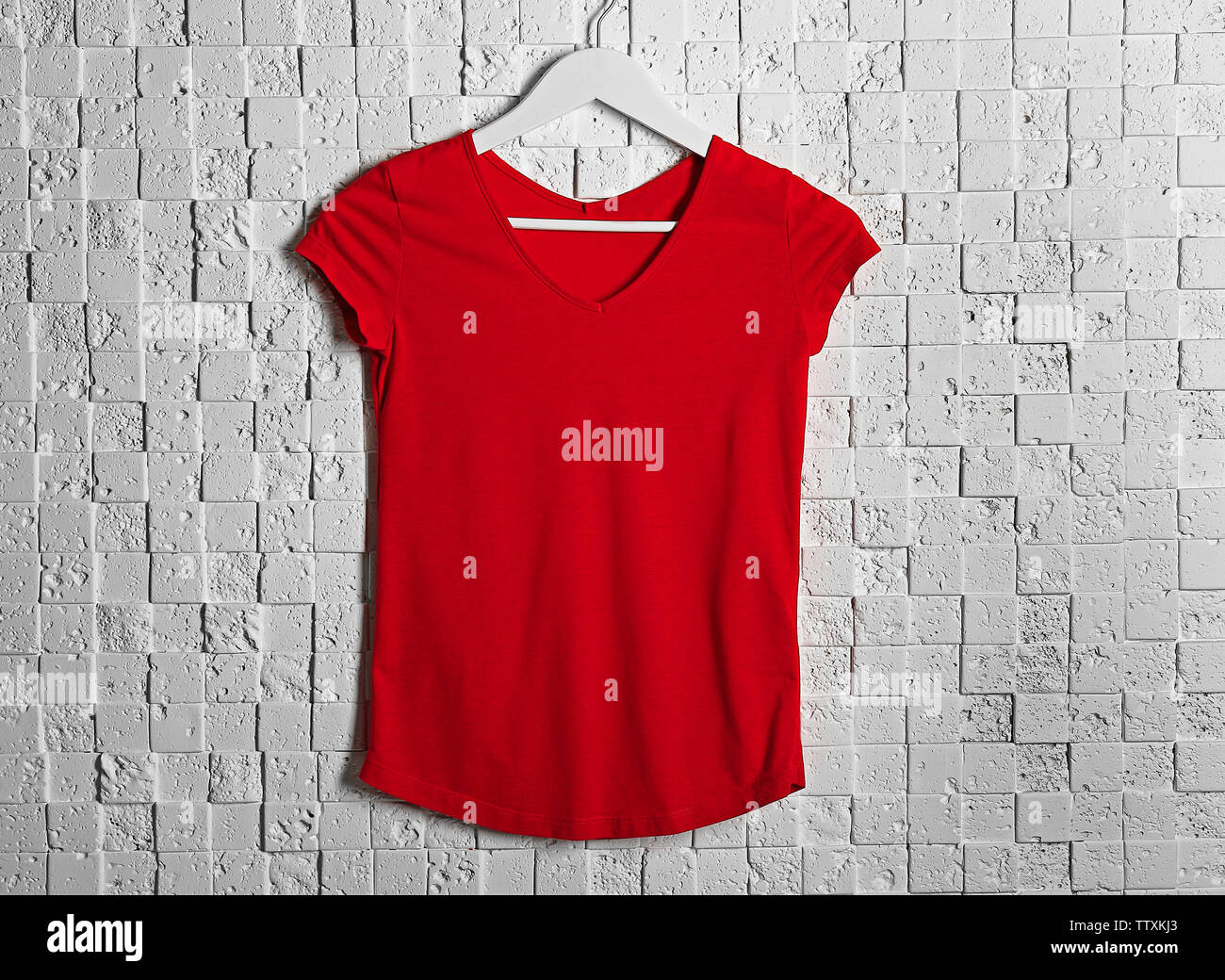 Blank red t-shirt against light textured background Stock Photo - Alamy