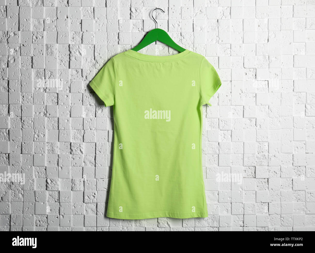 Blank color t-shirt against light textured background Stock Photo - Alamy
