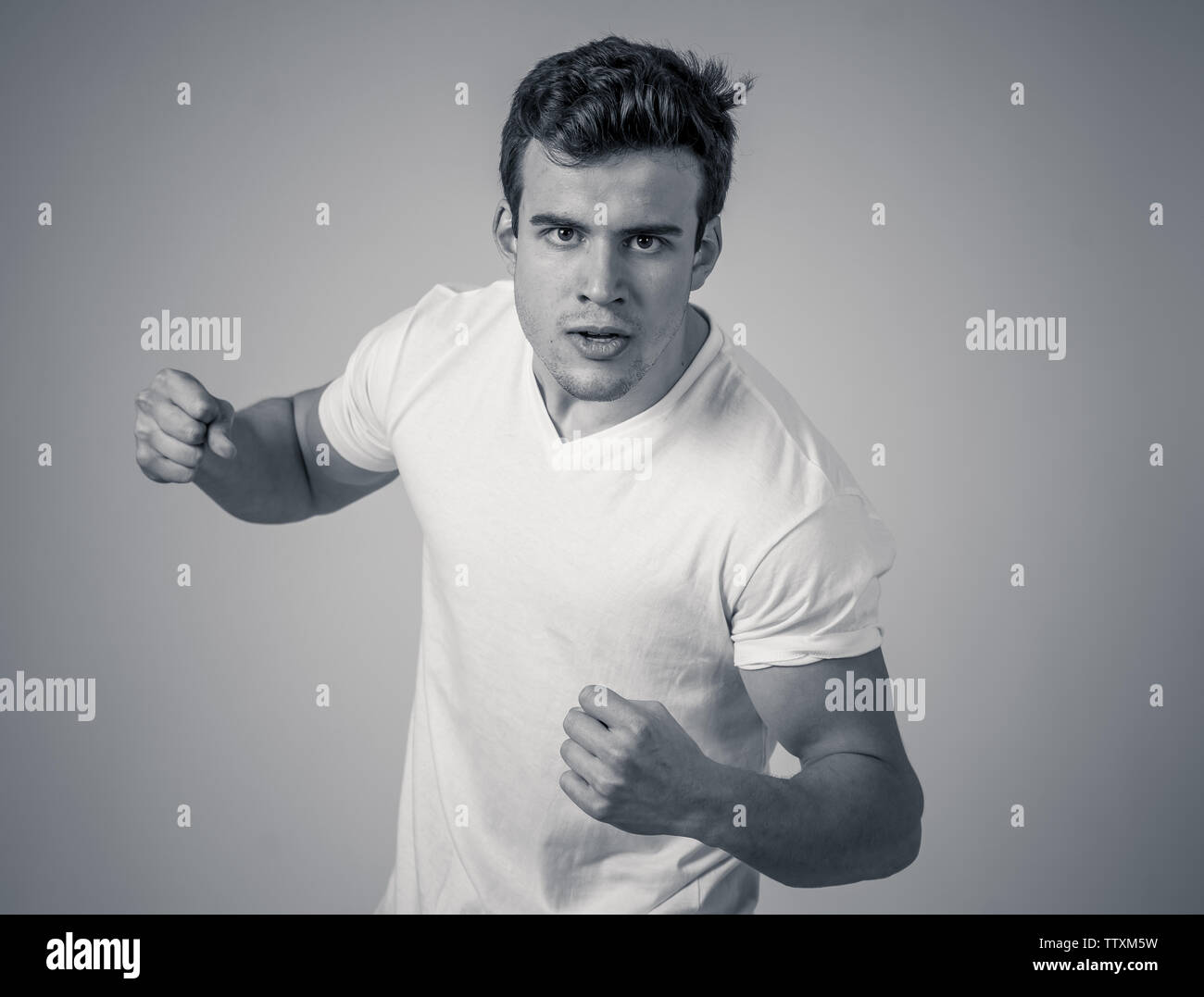 Young attractive man in rage looking furious in defence stance and ...
