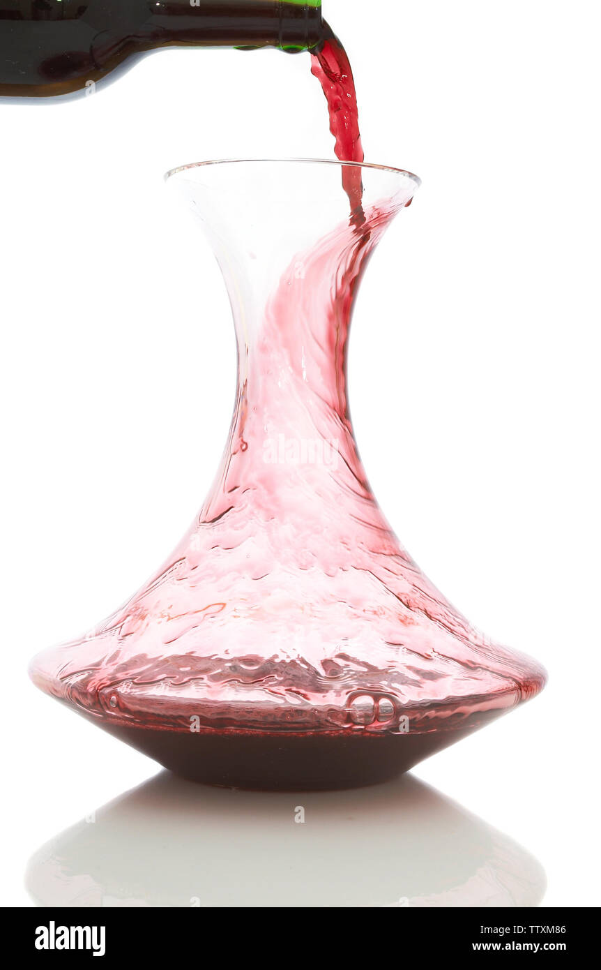 red wine pouring into carafe on white Stock Photo - Alamy