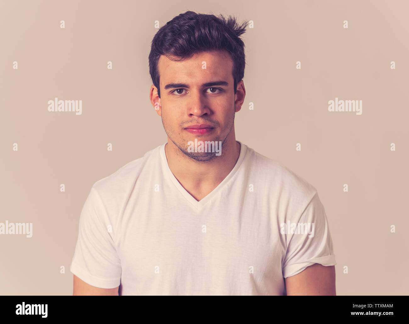 Close up headshot of young latin man with natural and neutral face and ...