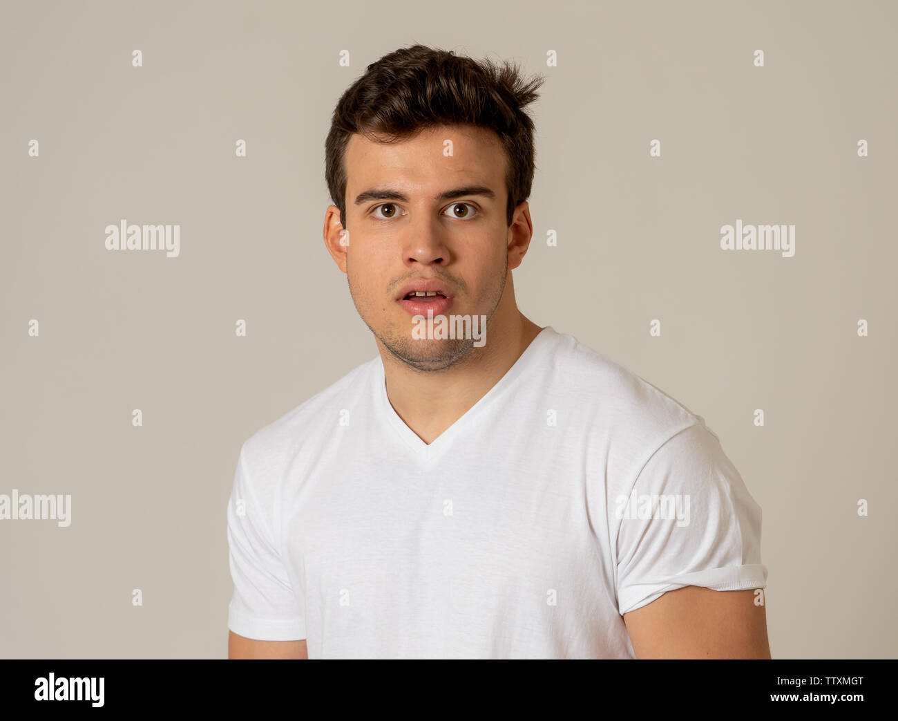 Portrait of handsome shocked young man hearing unexpected news. latin ...