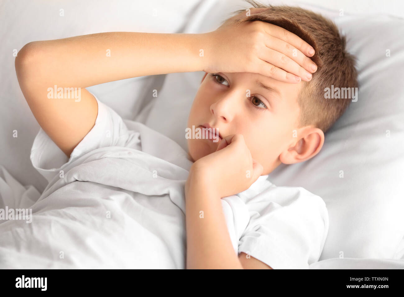 Small sick boy in bed Stock Photo - Alamy