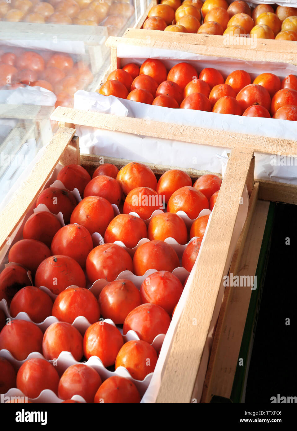 Fresh persimmons in wooden crate on market Stock Photo - Alamy