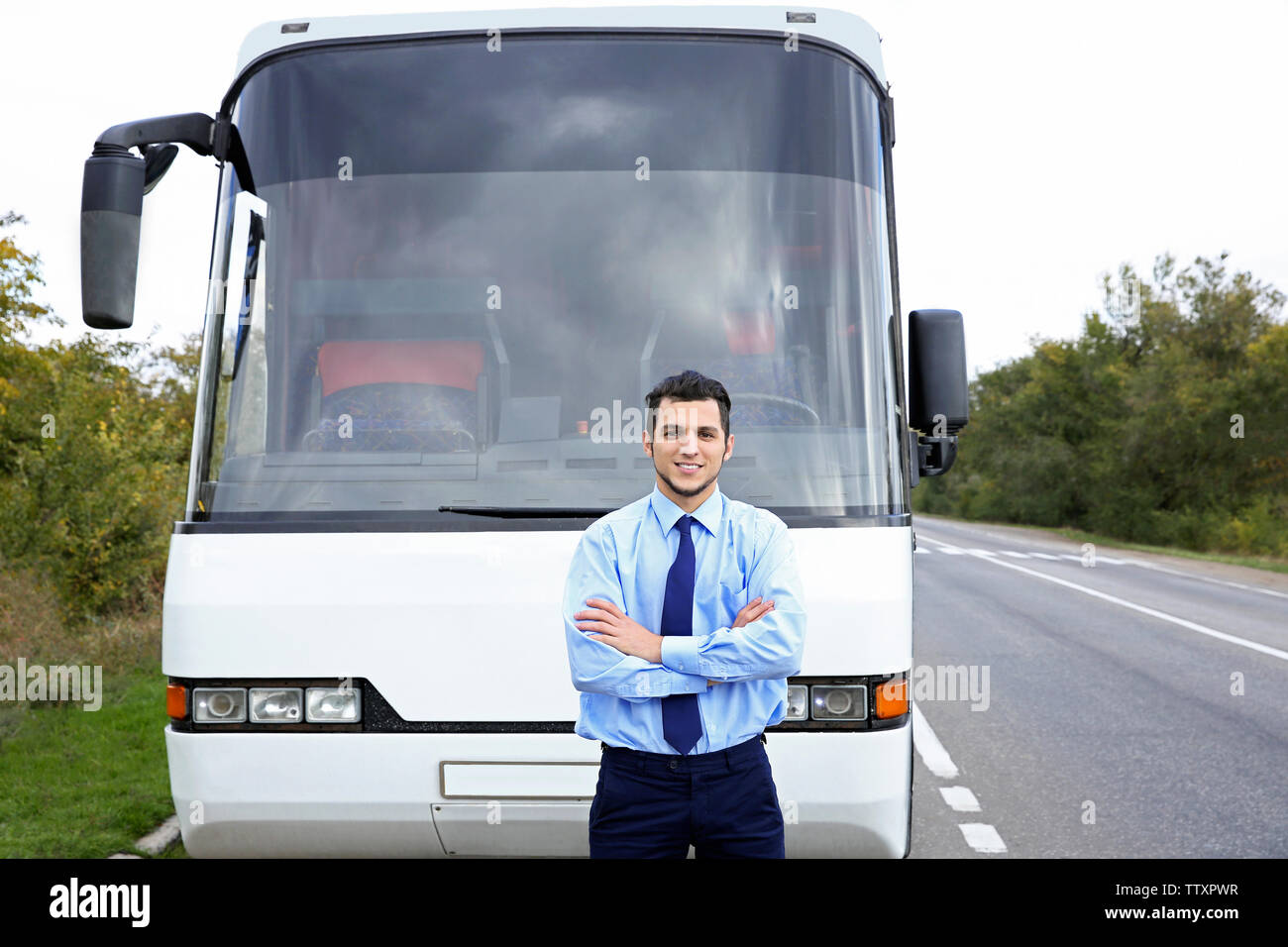 Driver standing in front of bus Stock Photo - Alamy