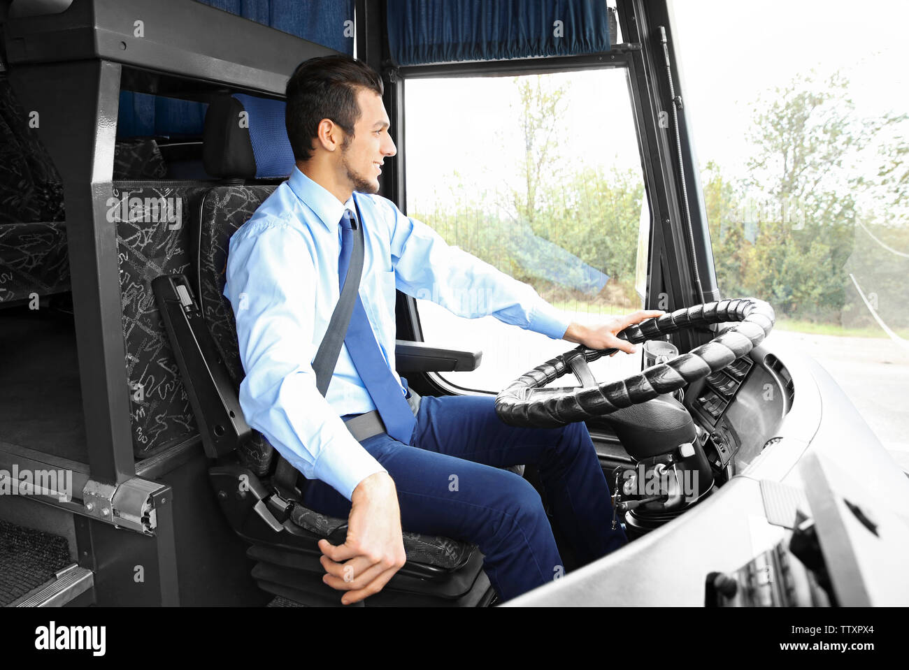 Handsome driver sitting in bus Stock Photo - Alamy