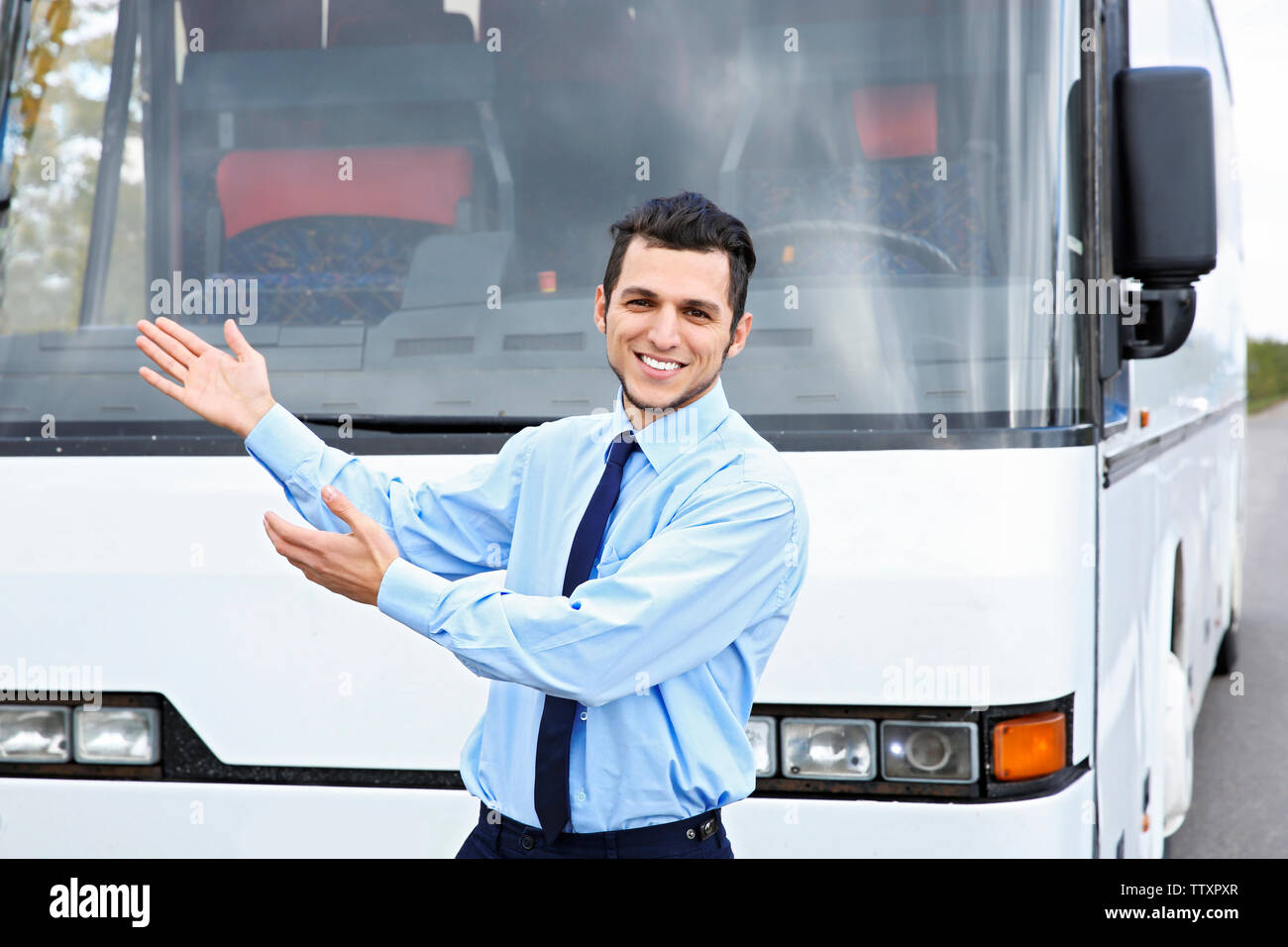 Driver standing in front of bus Stock Photo - Alamy
