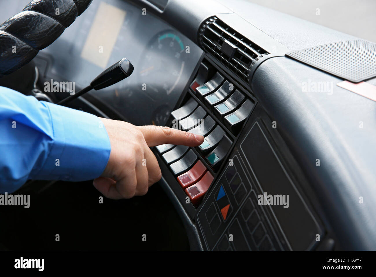 Bus driver pushing button on panel Stock Photo - Alamy