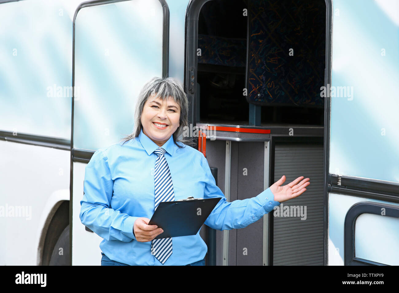 Female driver standing beside bus Stock Photo - Alamy