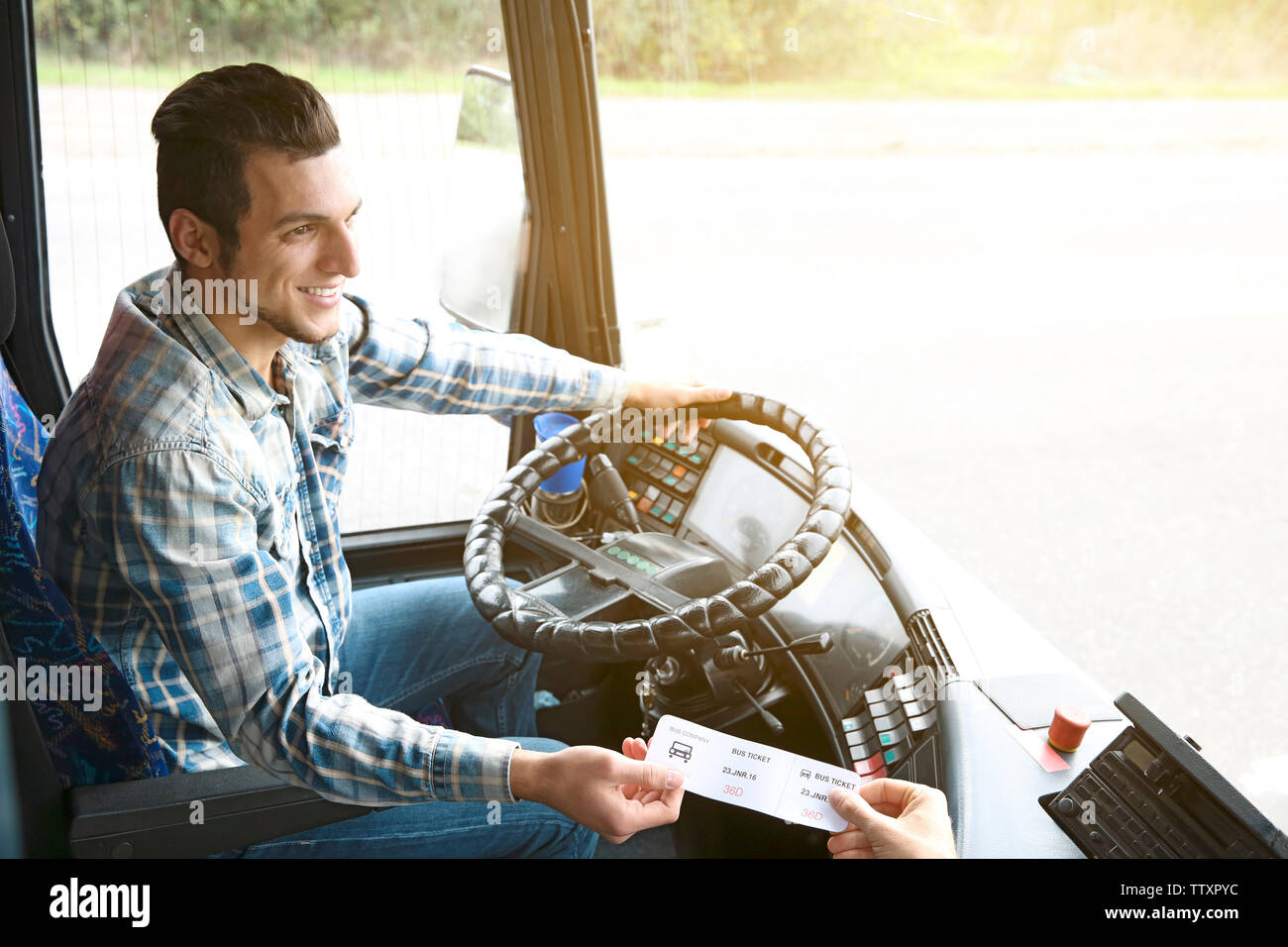 Bus driver taking ticket from passenger Stock Photo - Alamy