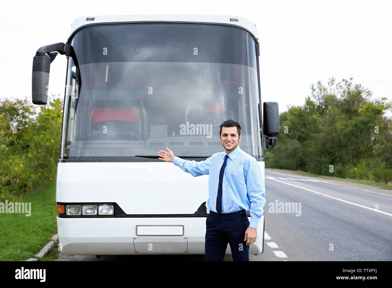 Driver standing in front of bus Stock Photo - Alamy