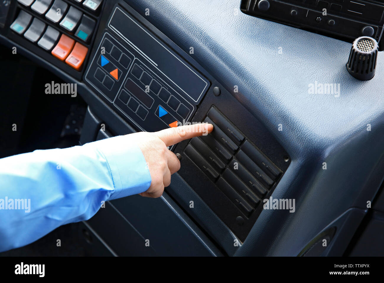 Bus driver pushing button on panel Stock Photo - Alamy
