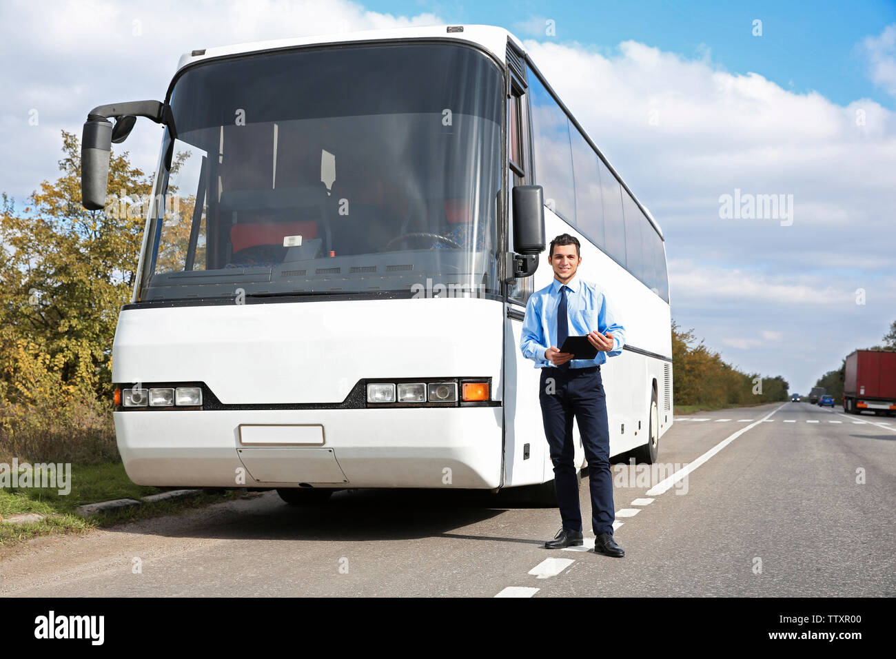 Driver standing in front of bus Stock Photo - Alamy