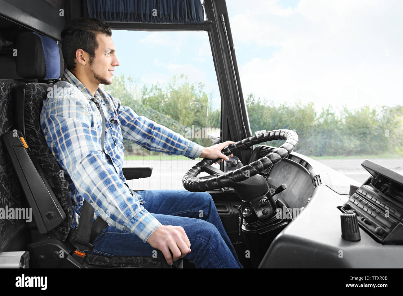 Handsome driver sitting in bus Stock Photo - Alamy