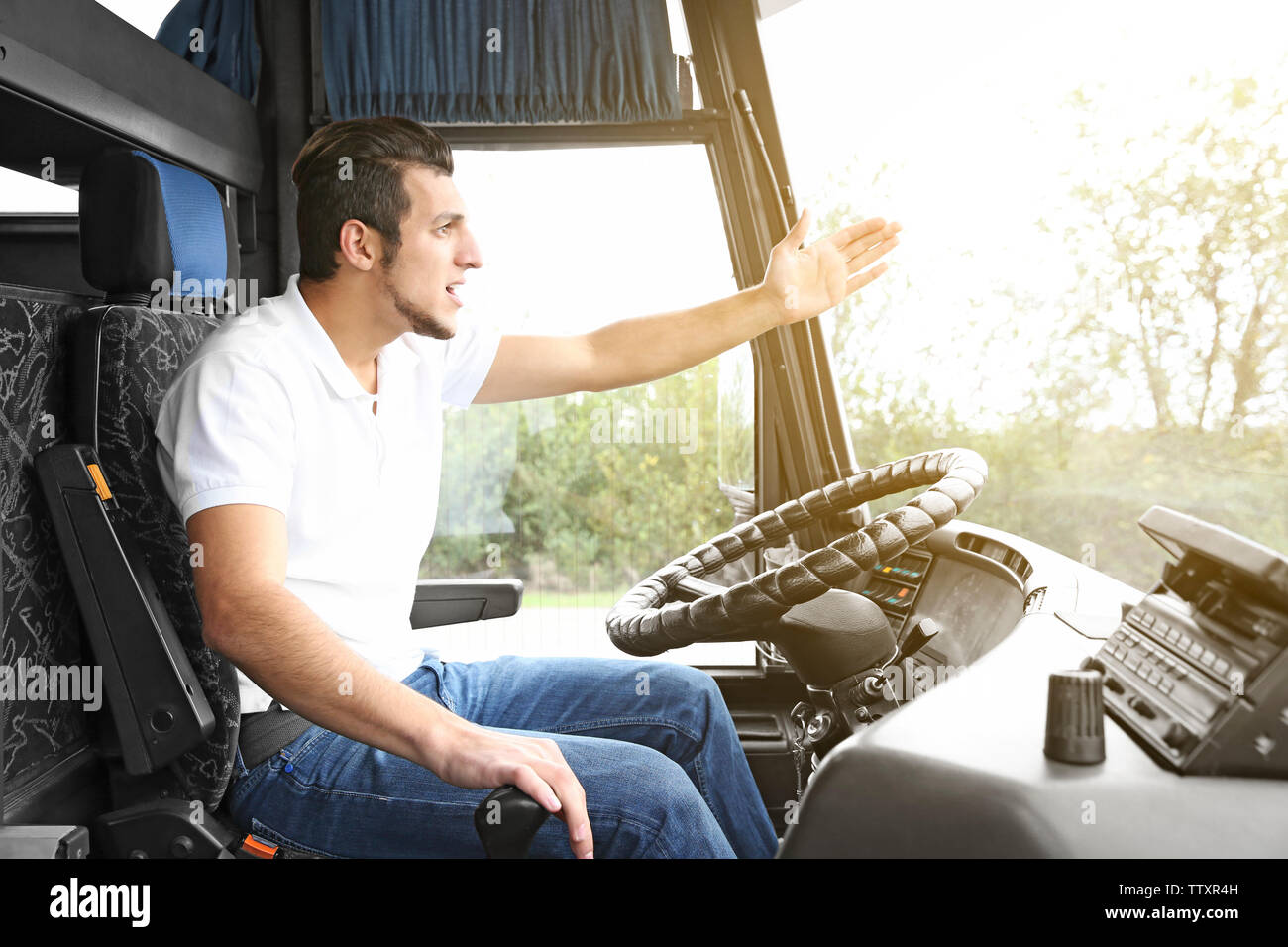 Handsome driver sitting in bus Stock Photo - Alamy