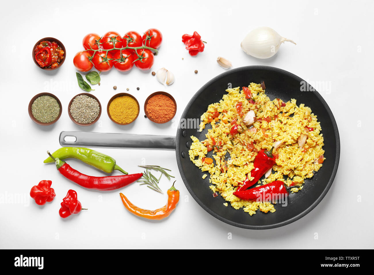 Cooked rice in pan and vegetables with spices on white background Stock ...