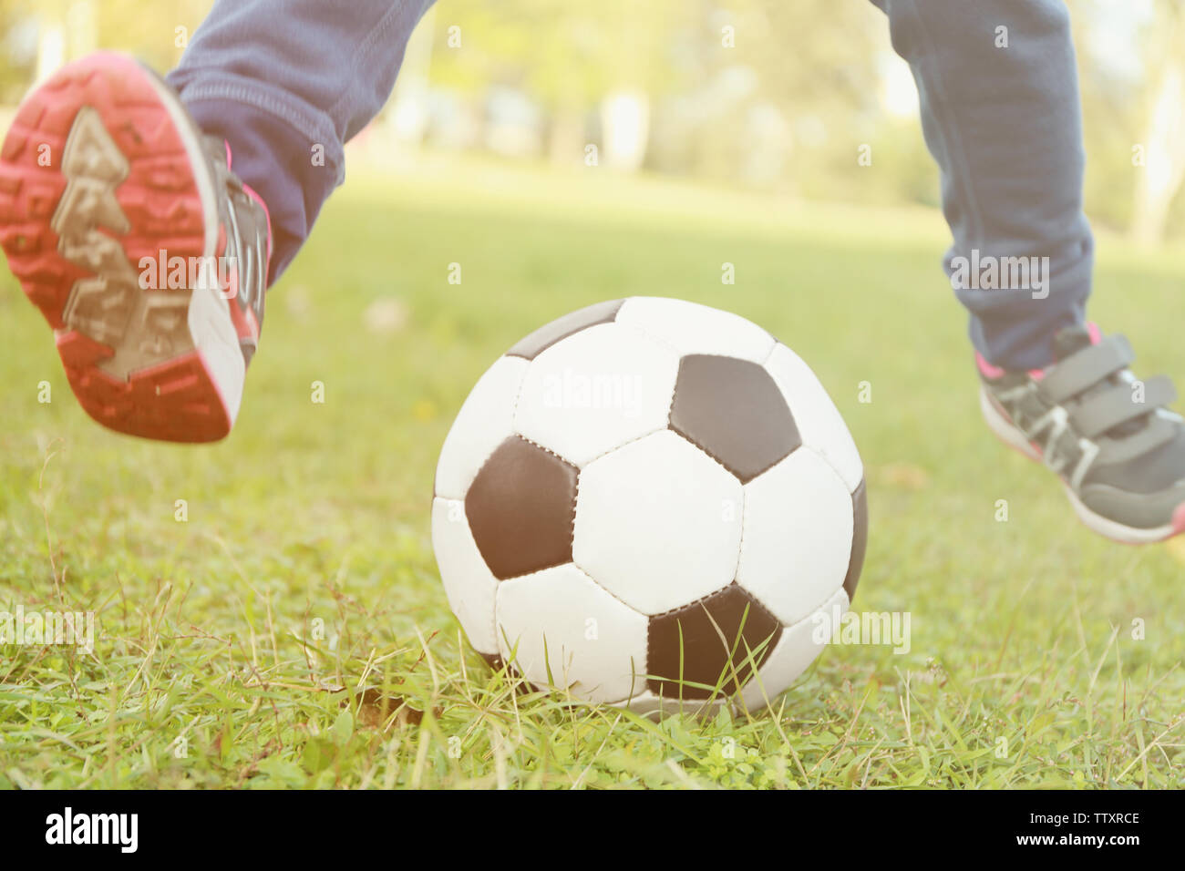 Close up view of boy's legs and ball on green grass Stock Photo - Alamy