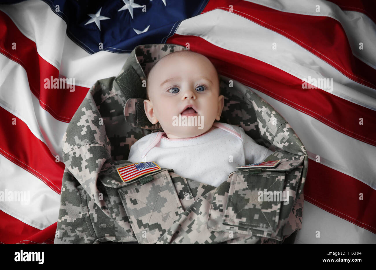 Cute baby on military clothing and flag Stock Photo - Alamy