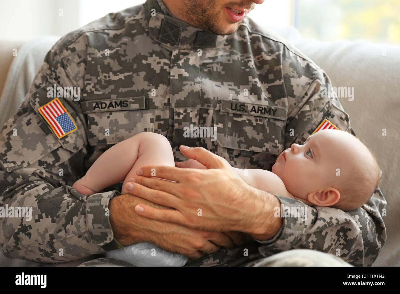 Military father holding his newborn baby Stock Photo - Alamy