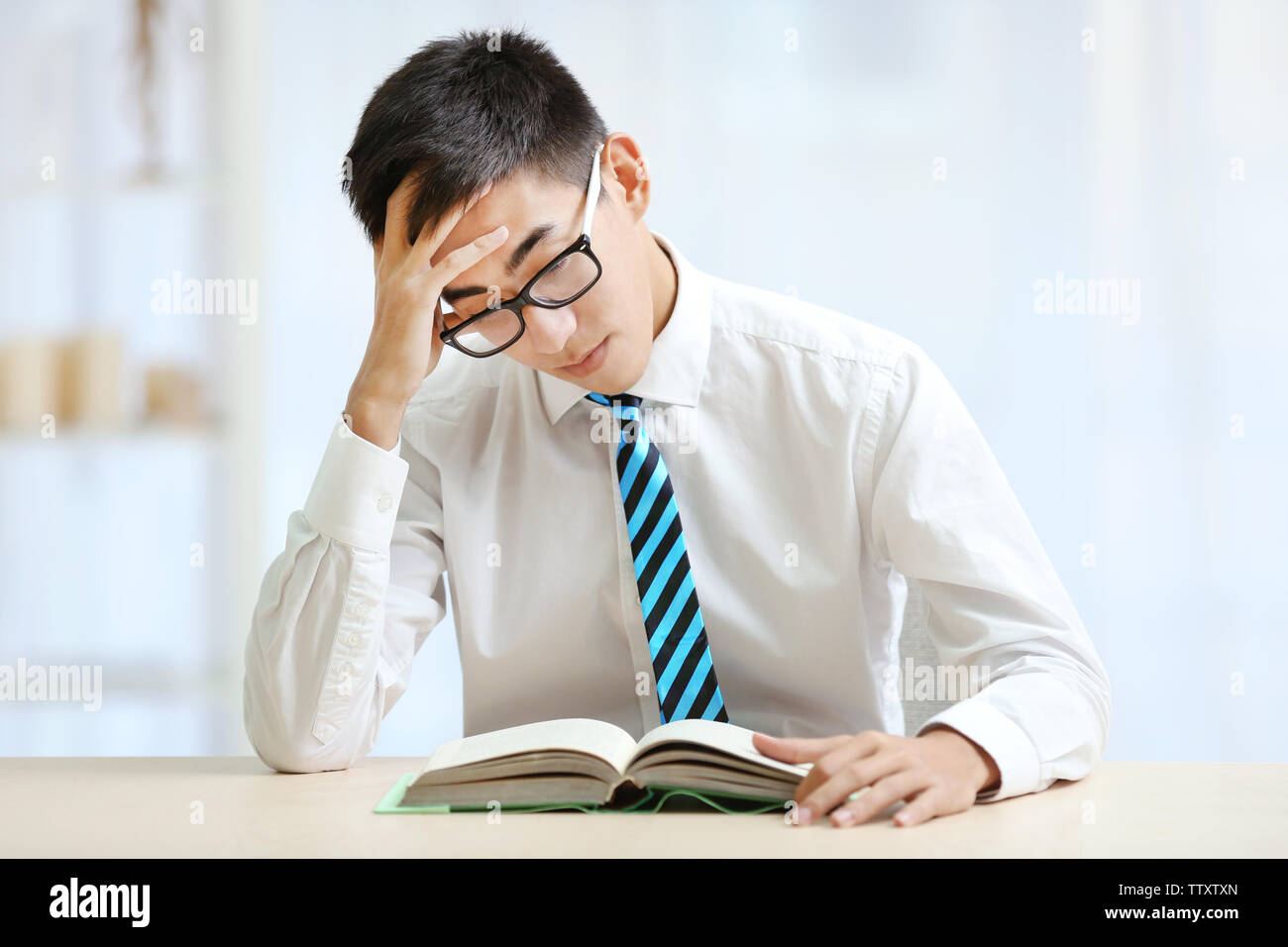 Student tired of studying in classroom Stock Photo - Alamy