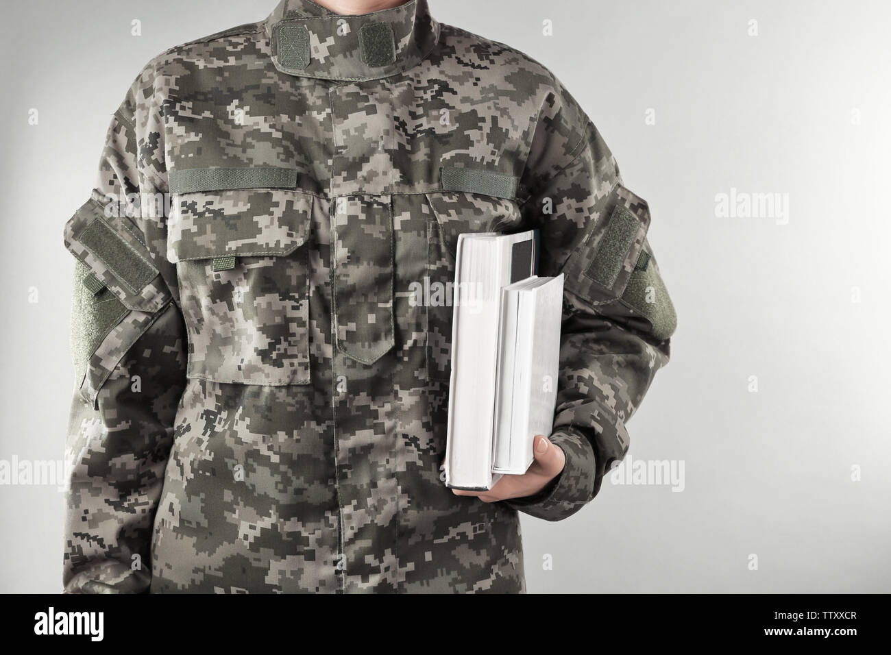 Soldier holding books. Military education concept Stock Photo - Alamy