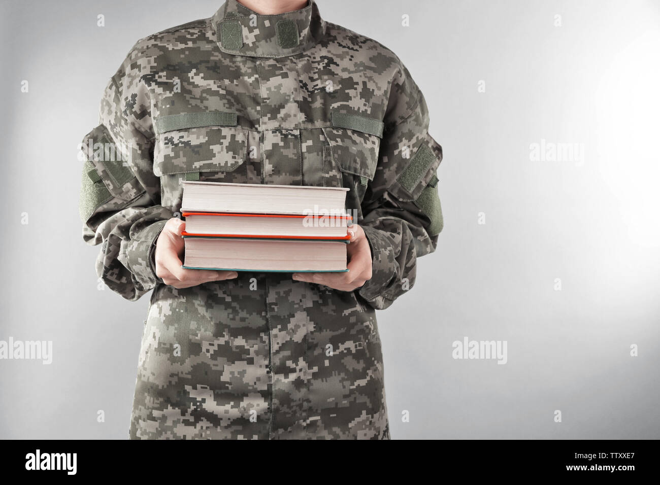 Soldier holding books. Military education concept Stock Photo - Alamy