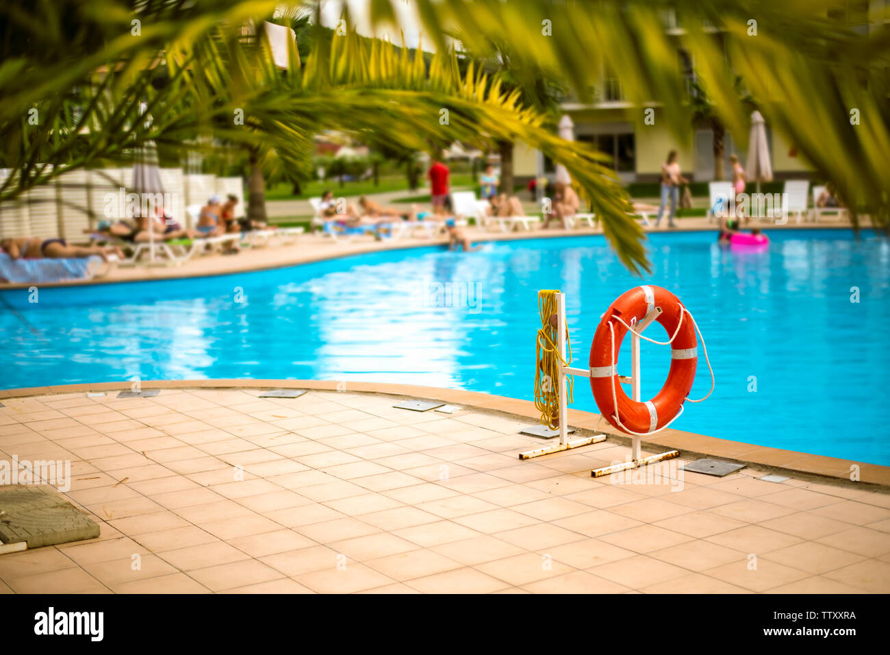 Lifebuoy life ring with rope attached to the post next to the pool in ...