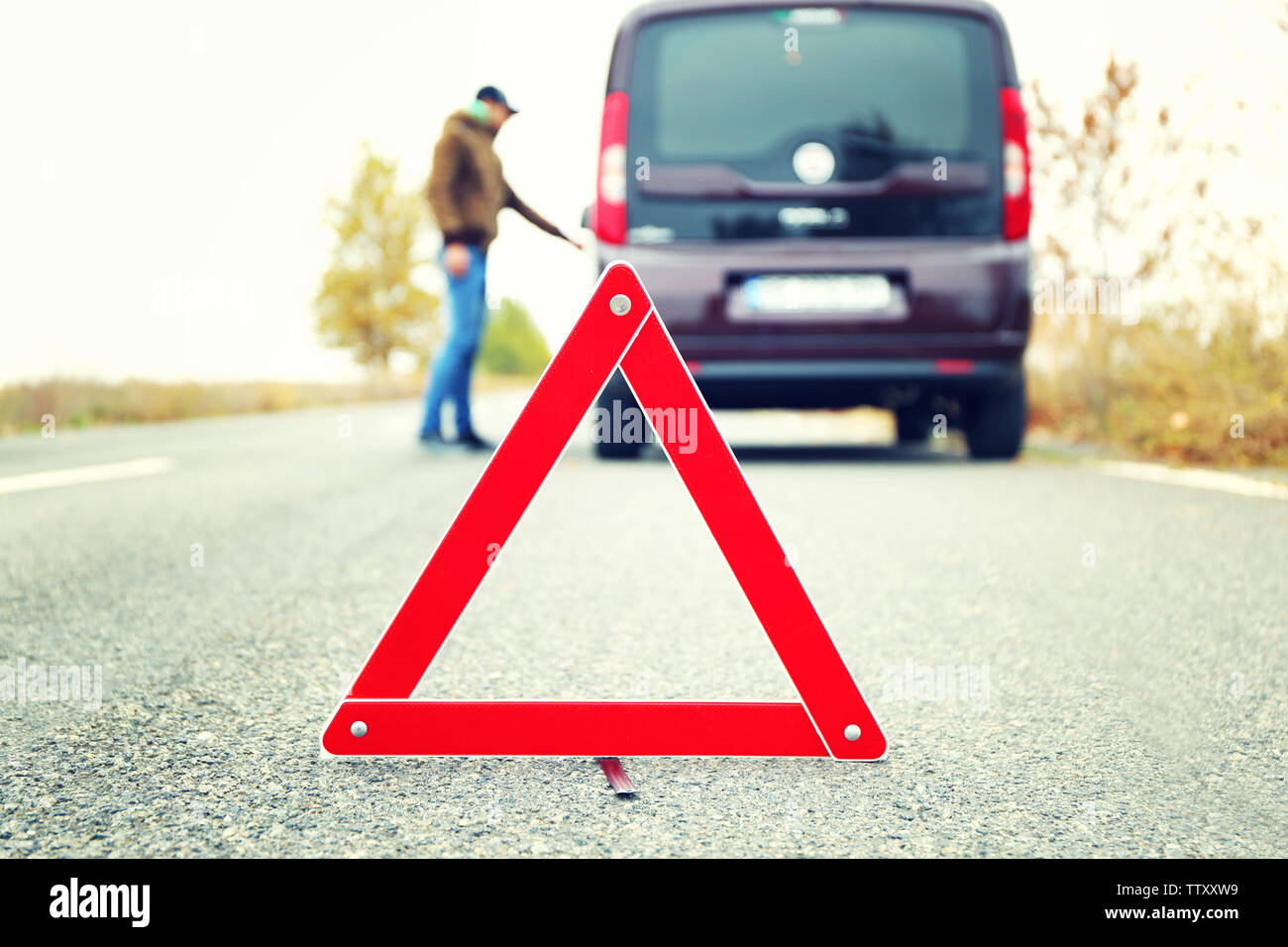 Traffic warning sign on road with car and driver on background Stock ...