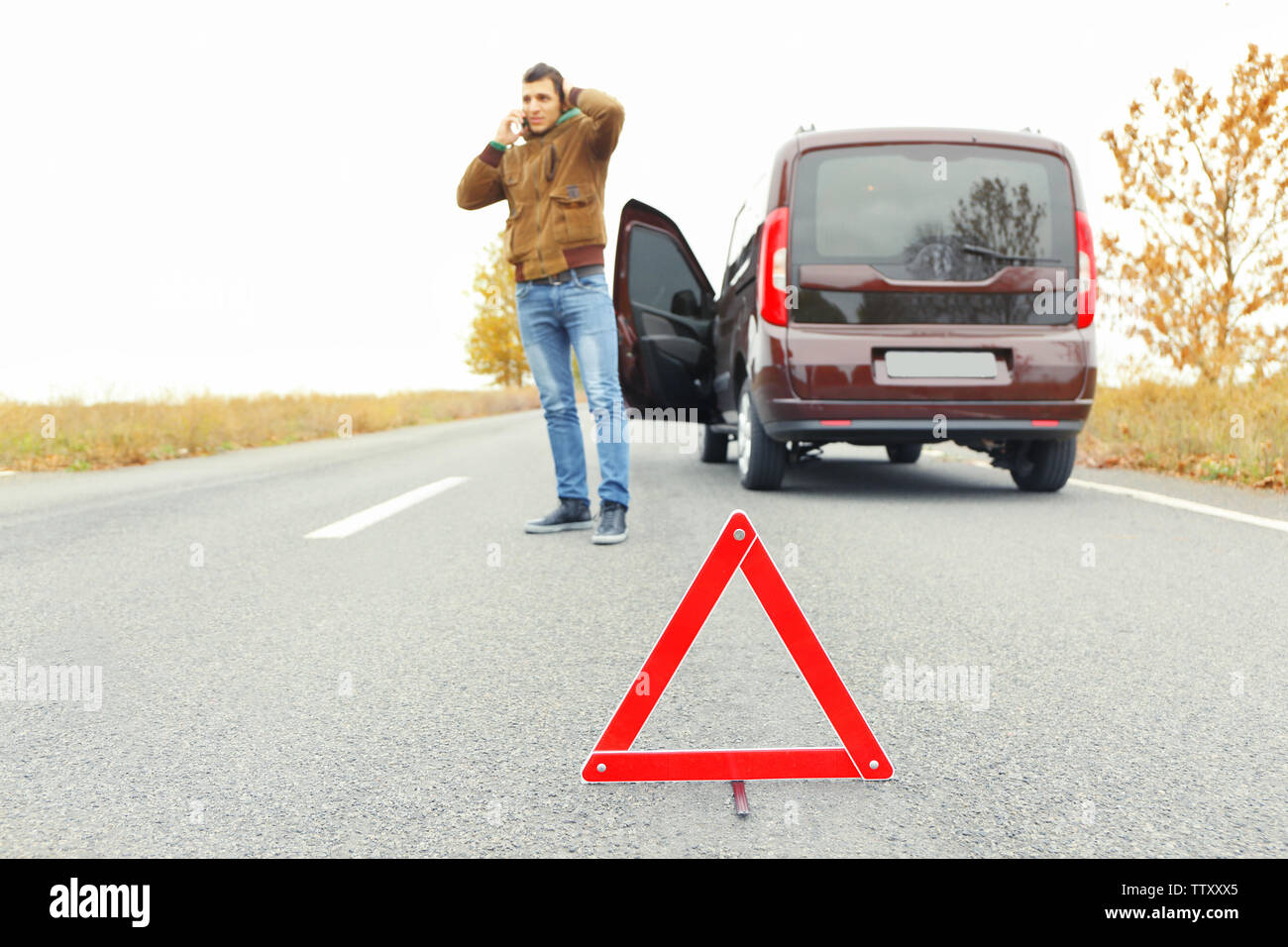 Traffic warning sign on road with car and driver on background Stock ...