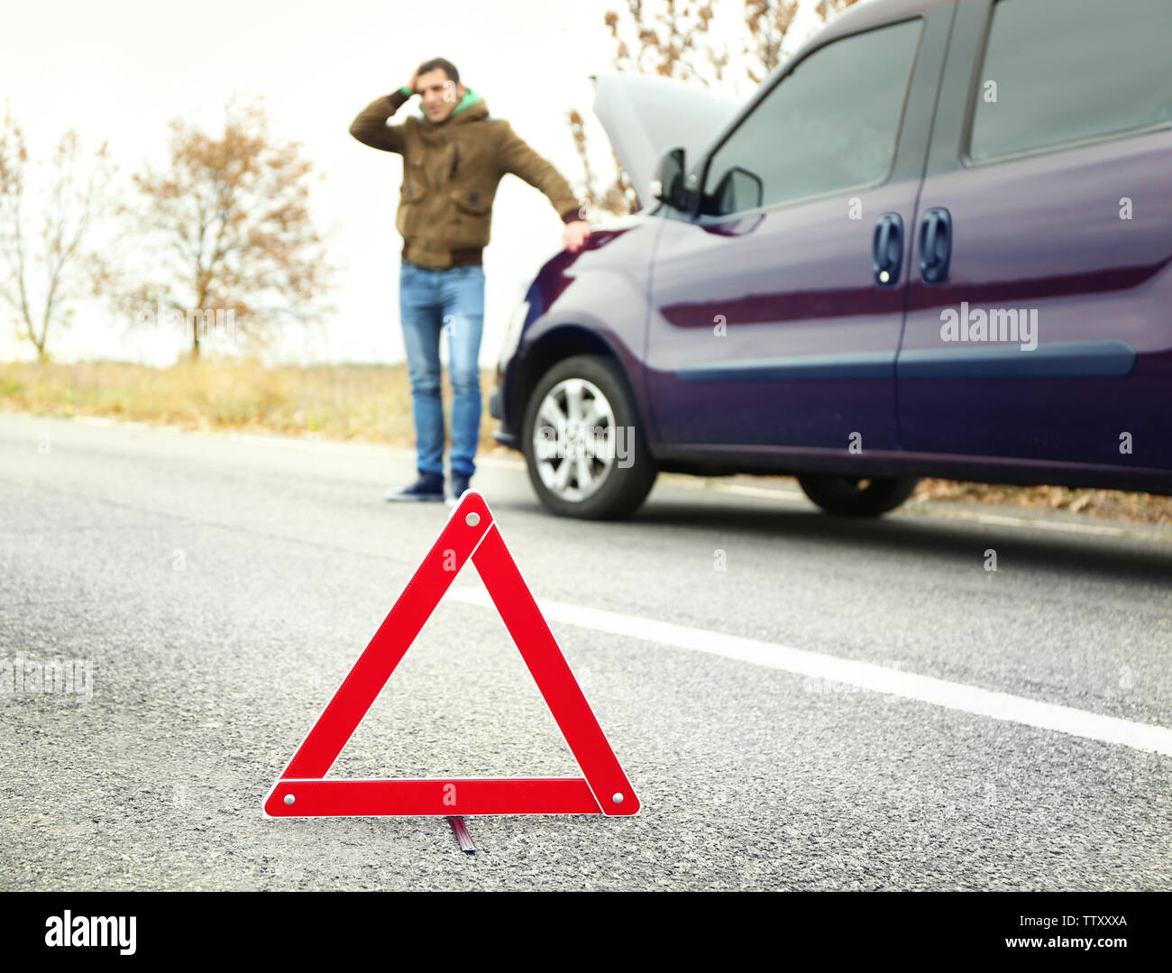 Traffic warning sign on road with car and driver on background Stock ...