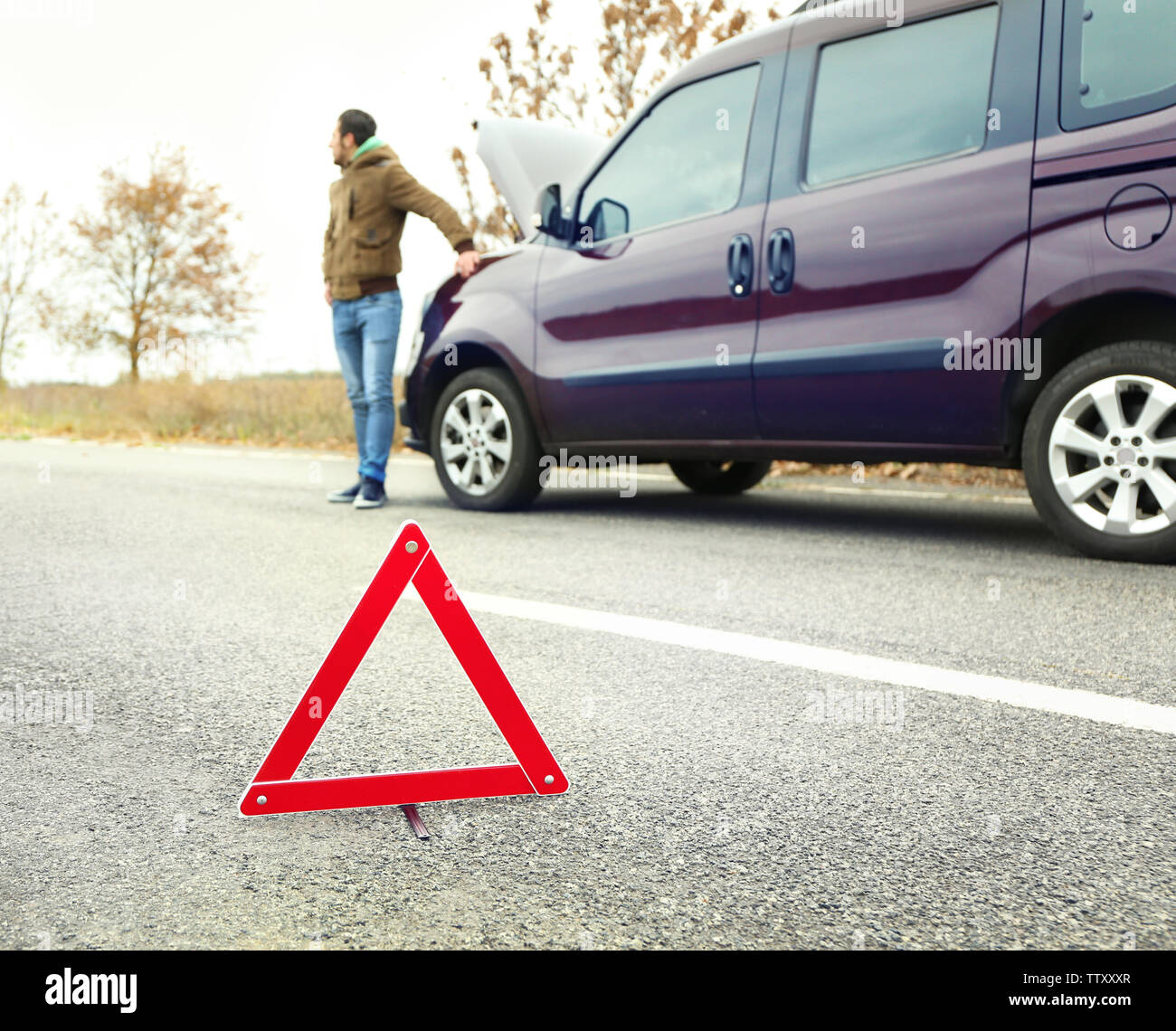 Traffic warning sign on road with car and driver on background Stock ...