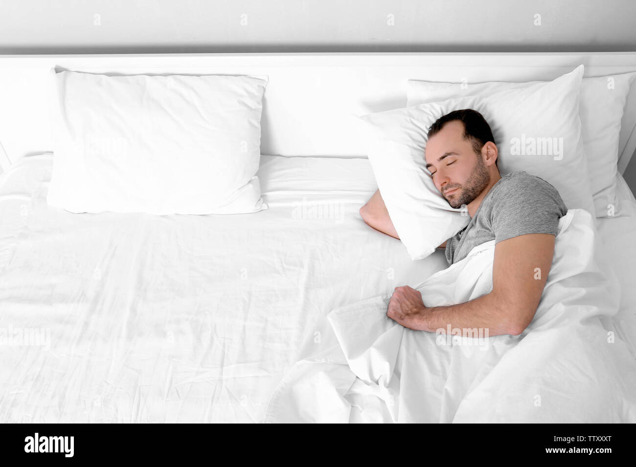Tired young man sleeping in bed Stock Photo - Alamy