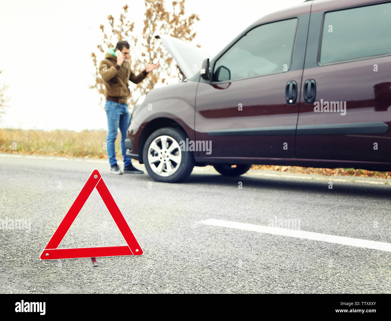 Traffic warning sign on road with car and driver on background Stock ...