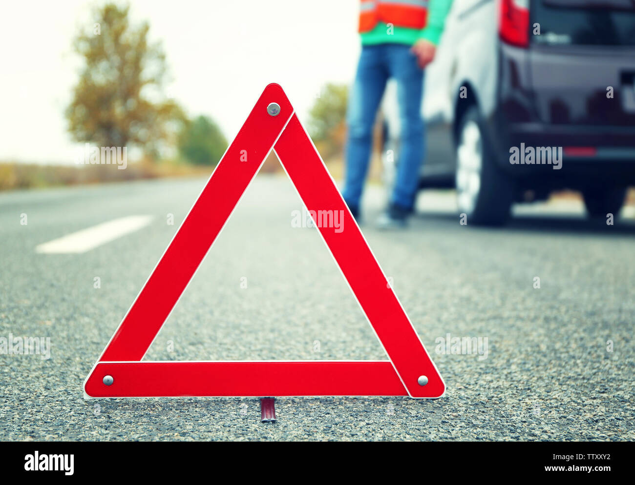 Traffic warning sign on road with car and driver on background Stock ...