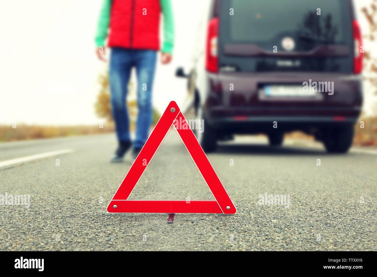 Traffic warning sign on road with car and driver on background Stock ...
