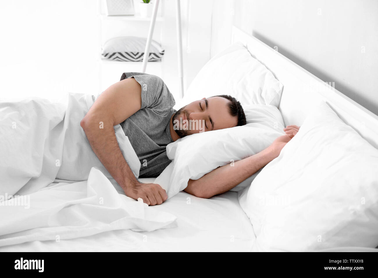 Tired young man sleeping in bed Stock Photo - Alamy