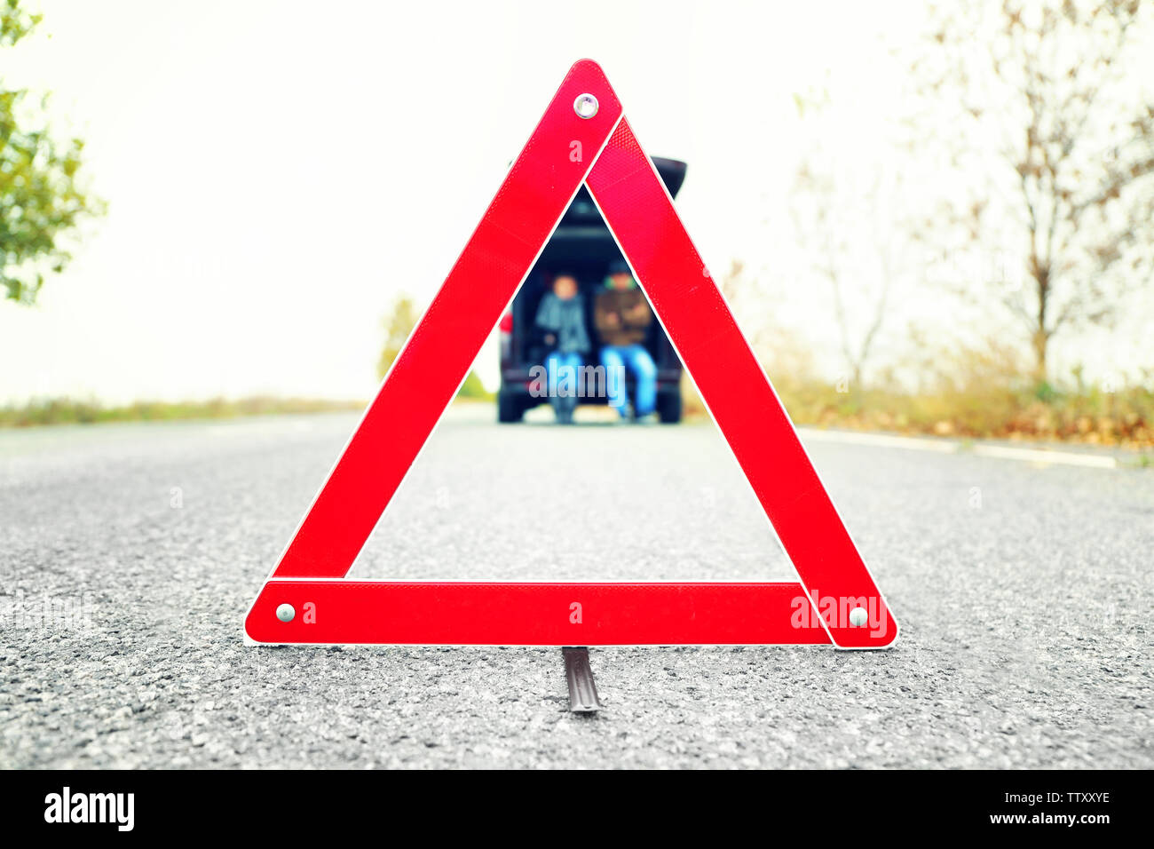 Traffic warning sign on road with car and couple on background Stock ...