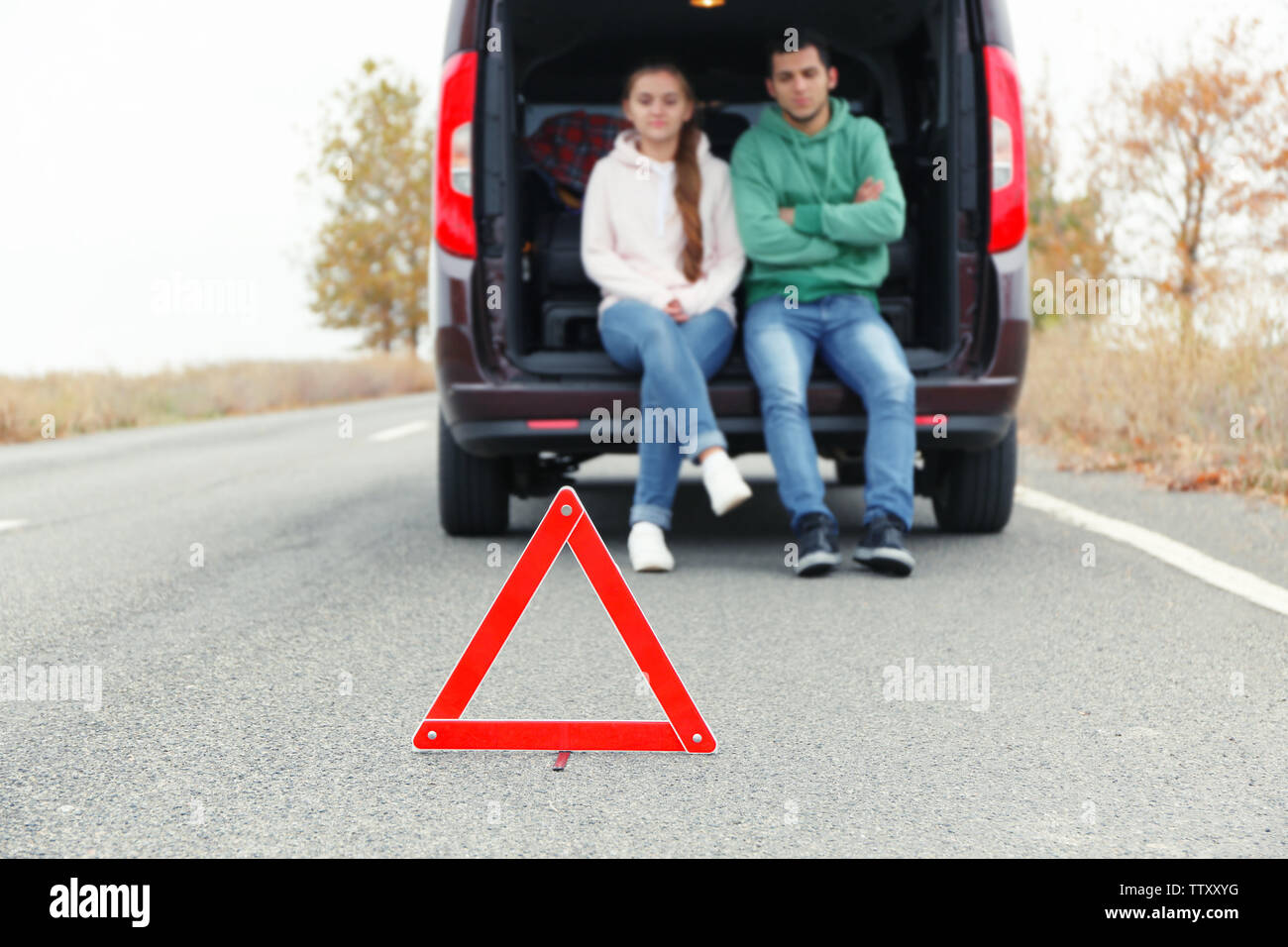 Traffic warning sign on road with car and couple on background Stock ...