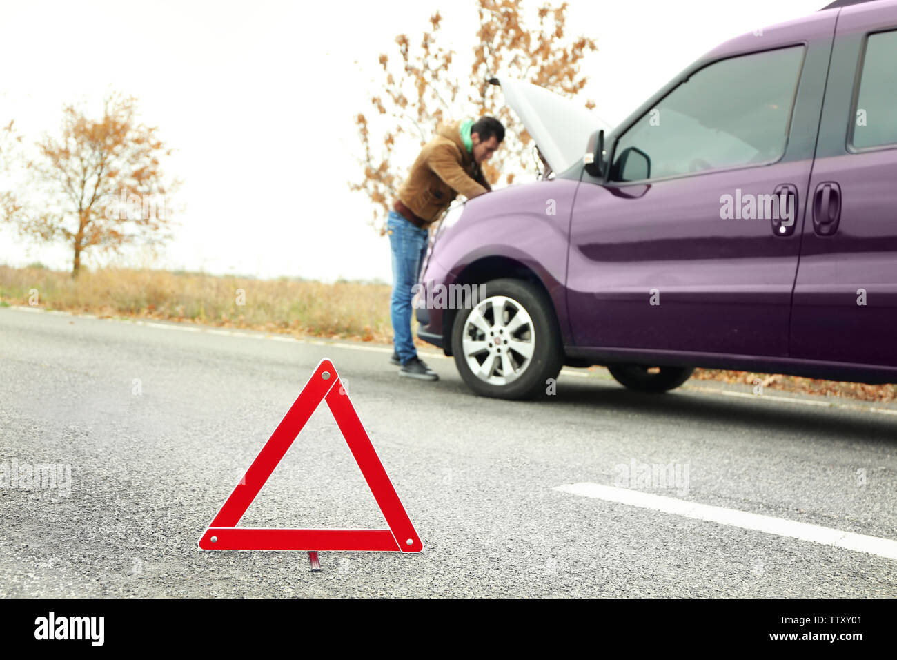 Traffic warning sign on road with car and driver on background Stock ...