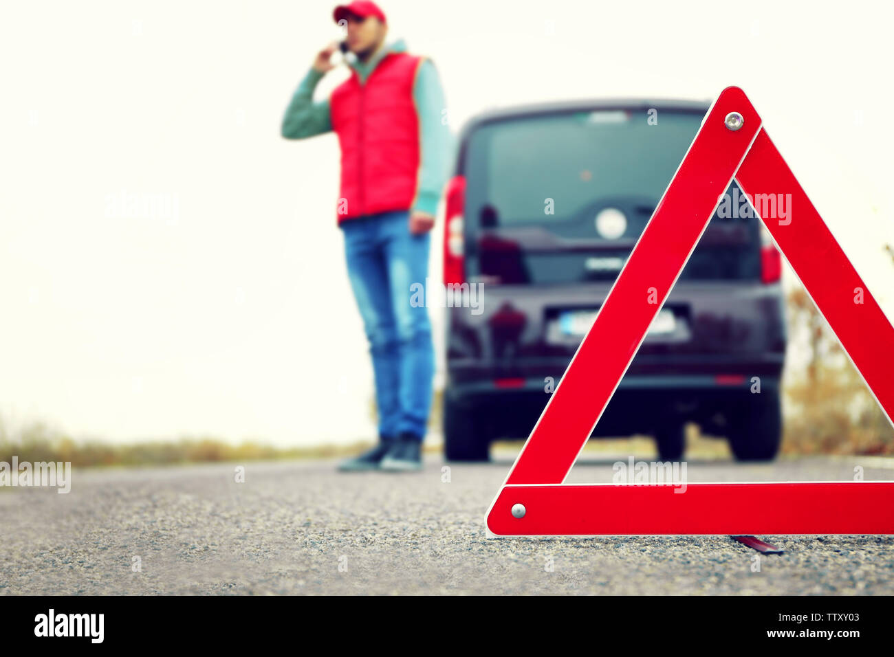 Traffic warning sign on road with car and driver on background Stock ...
