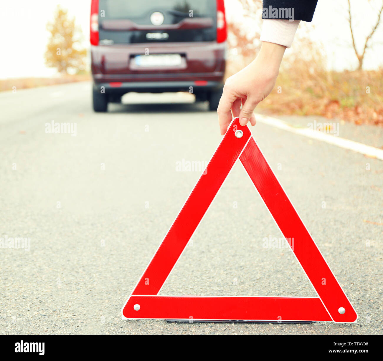 Driver putting out a traffic warning sign on road Stock Photo - Alamy