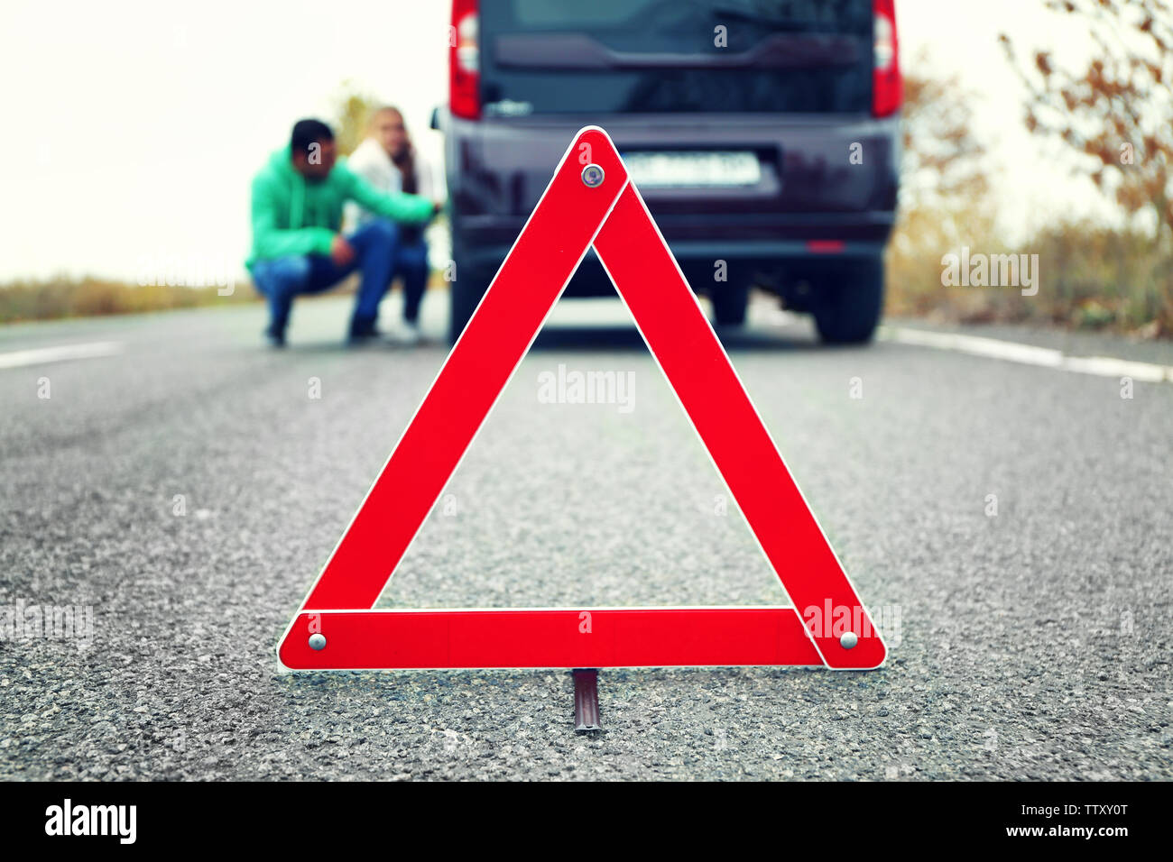 Traffic warning sign on road with car and couple on background Stock ...