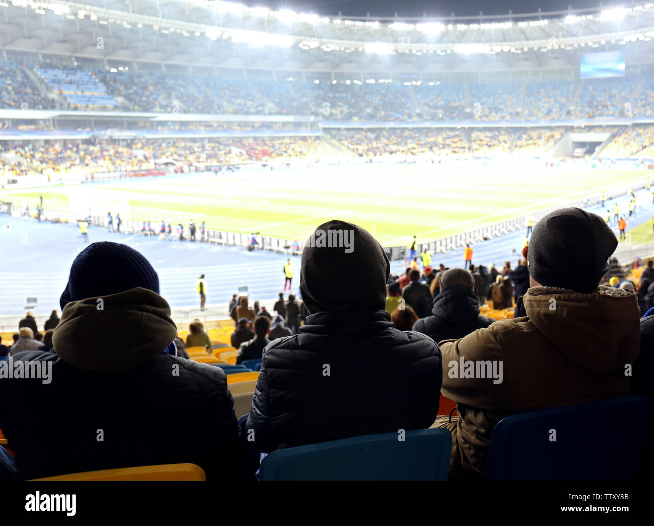 Fans watching football game at stadium Stock Photo - Alamy