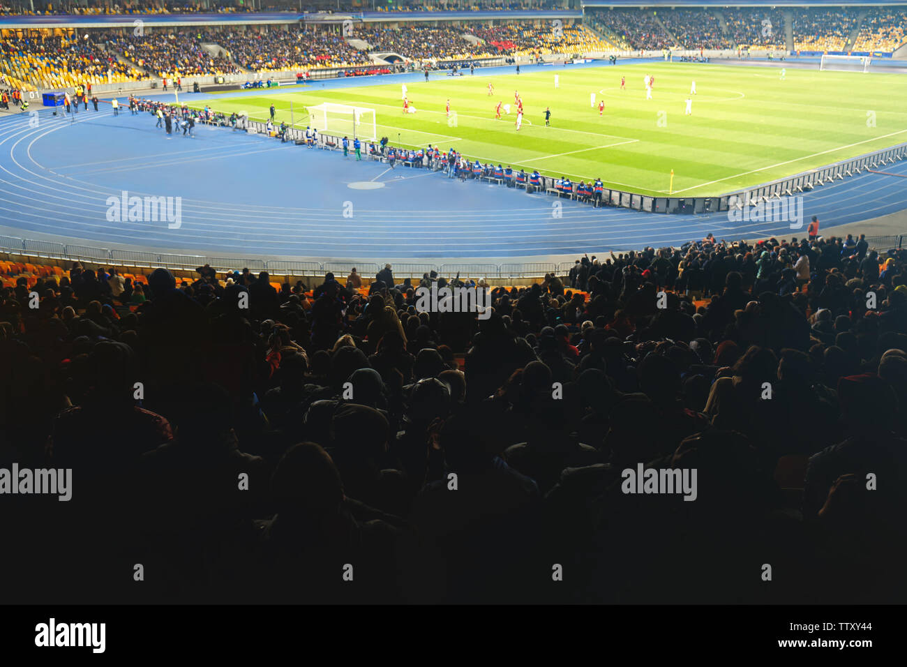 Fans watching football game at stadium Stock Photo - Alamy