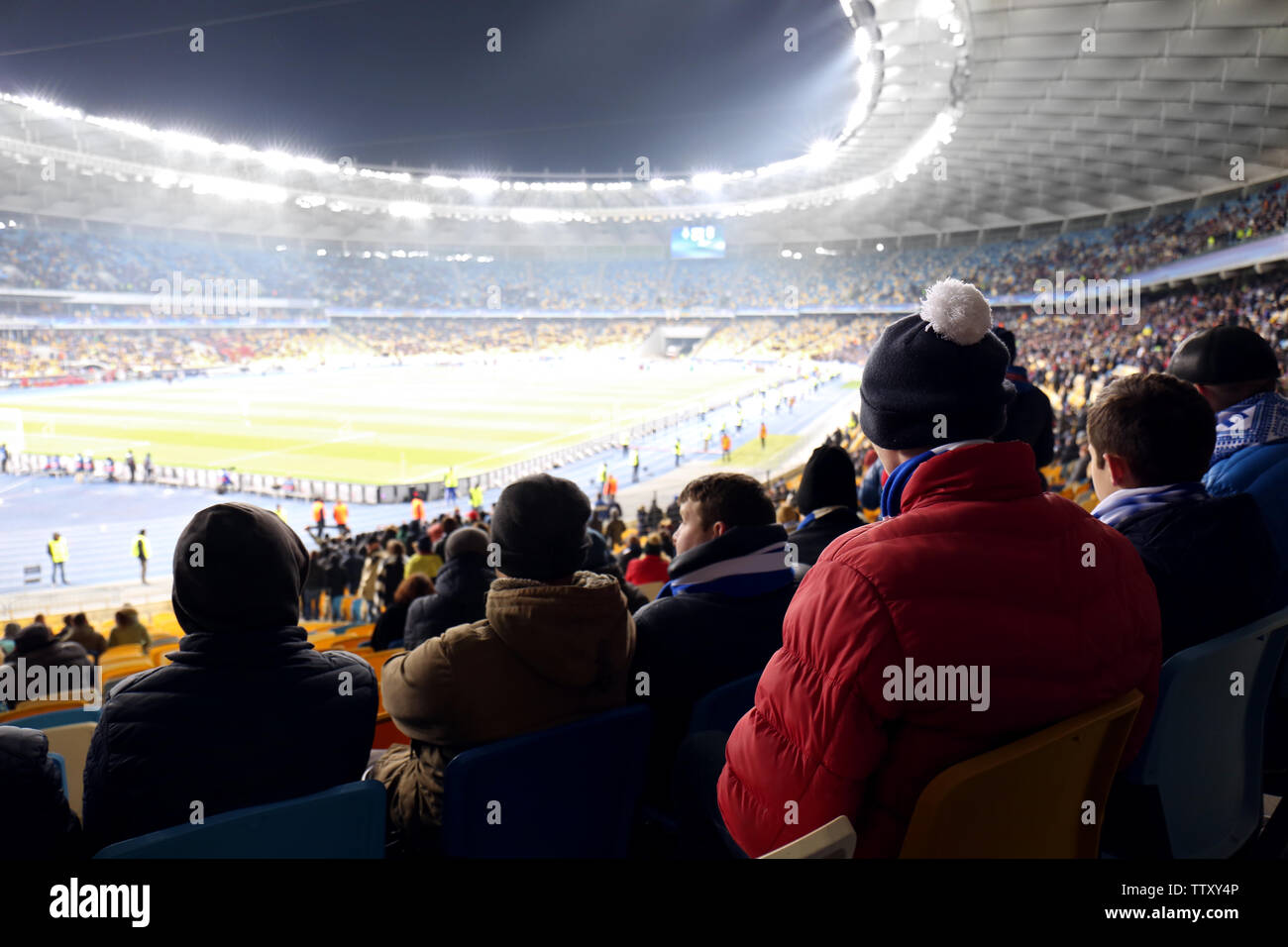 Fans watching football game at stadium Stock Photo - Alamy