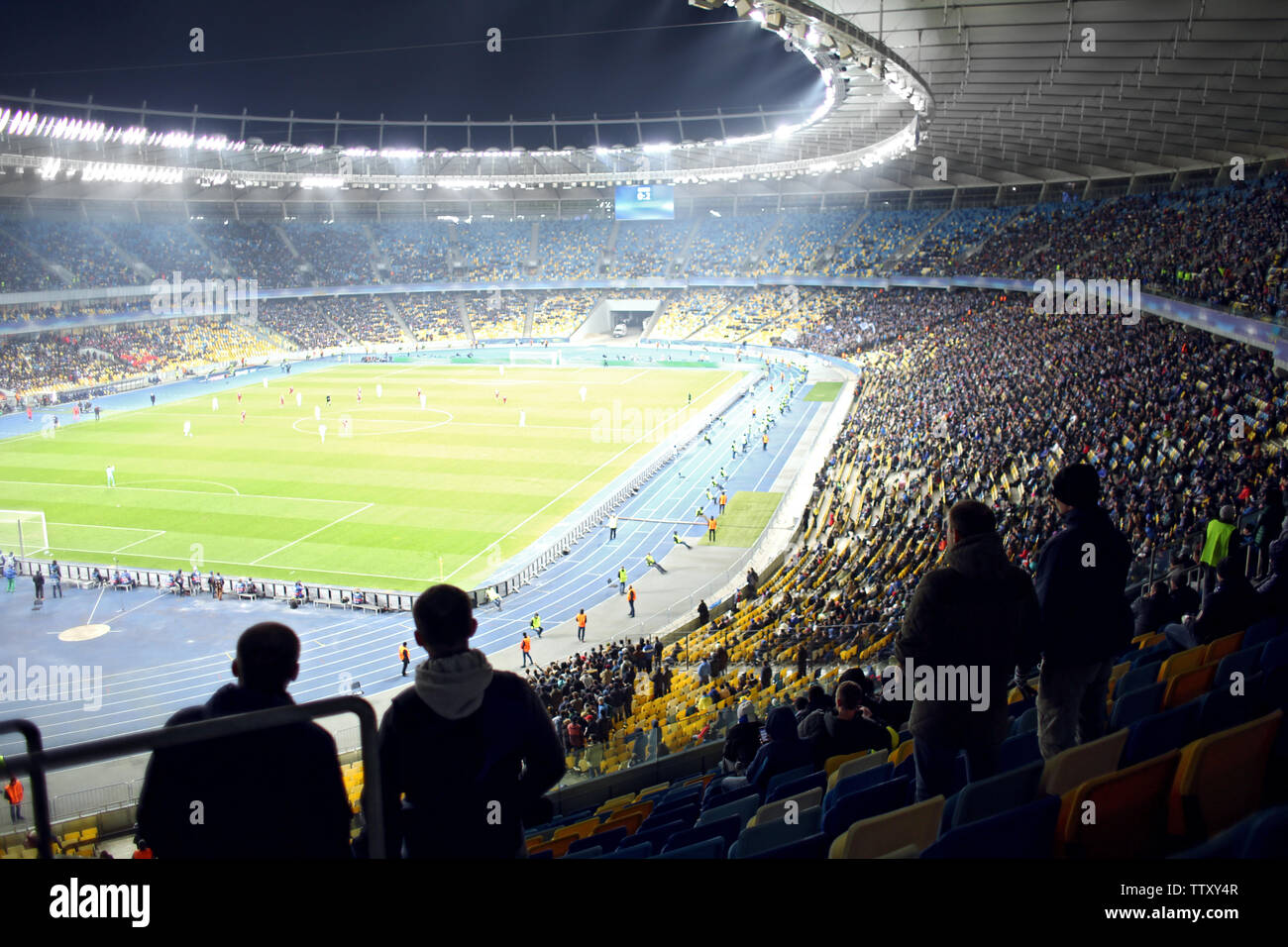 Fans watching football game at stadium Stock Photo - Alamy