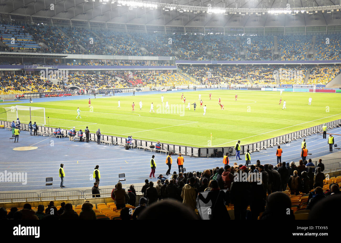 Fans watching football game at stadium Stock Photo - Alamy