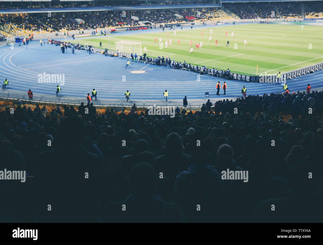 Fans watching football game at stadium Stock Photo - Alamy