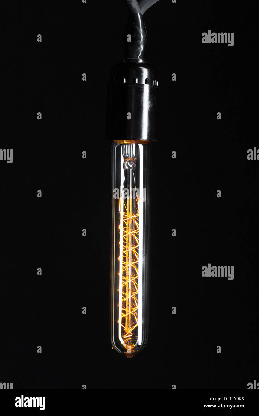 A classic Edison light bulb on dark background with space for text ...